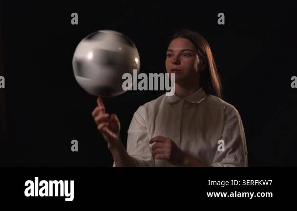 Young woman in a white shirt balances a transparent glass bowl on one ...