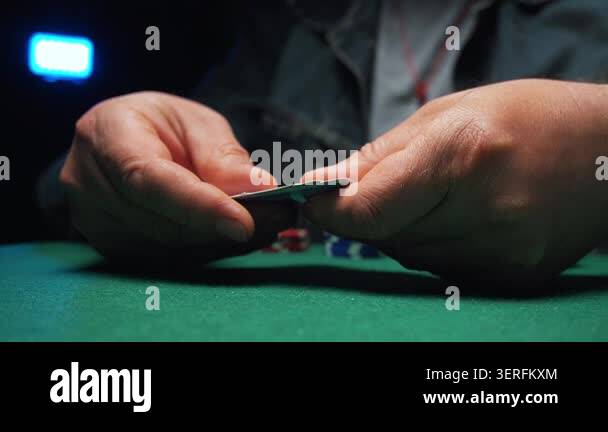 A male gambler with visible hands holding a deck of playing cards shows ...