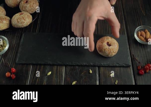 Hand carefully positions traditional baked sweets on a slate serving ...