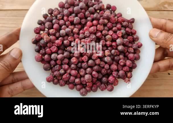 Phalsa berries served in white plate on wooden table during summer ...