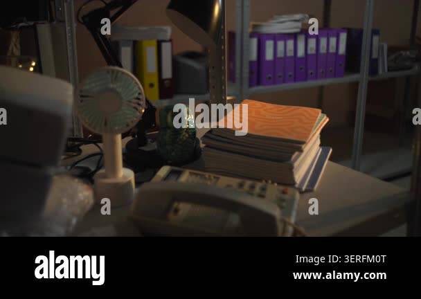 A cluttered office workspace with stacked folders, scattered papers ...