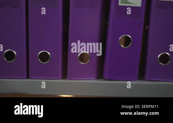Close-up front view of upright purple office binders arranged in a tidy ...