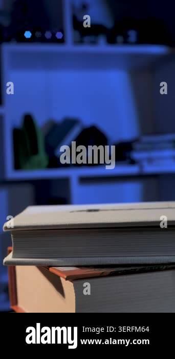 Hardback books being placed on a wooden table, educational collection ...