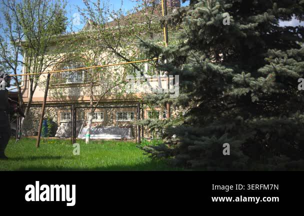 Bright daytime exterior of a two-story residential house partly framed ...