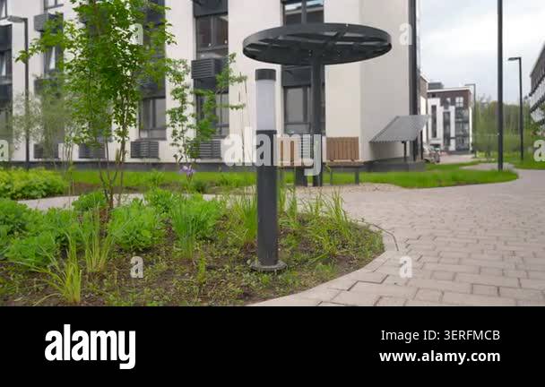 A quiet paved courtyard in a modern apartment complex features ...