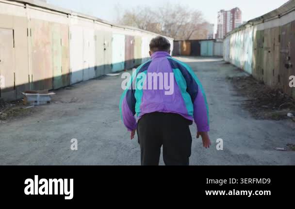 Single Pursuer Running Through Garage Alley In Purple Jacket ...
