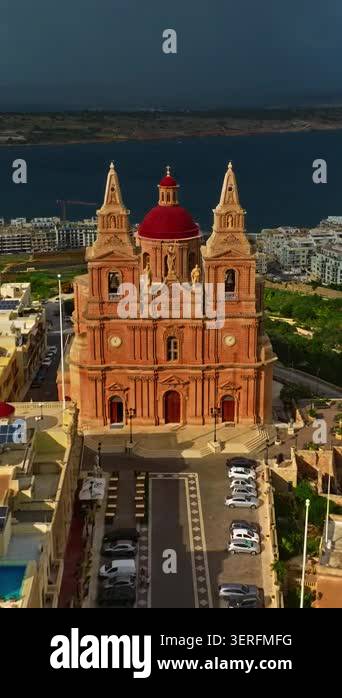 Aerial view of the Mellieha Church with red dome and the sea in the ...