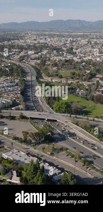 Fly above large city. Heavy traffic on multilane highway and buildings ...