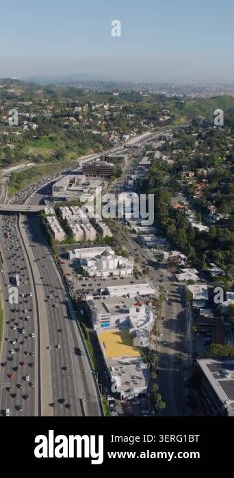 Aerial panoramic view of multilane freeway leading between hills ...