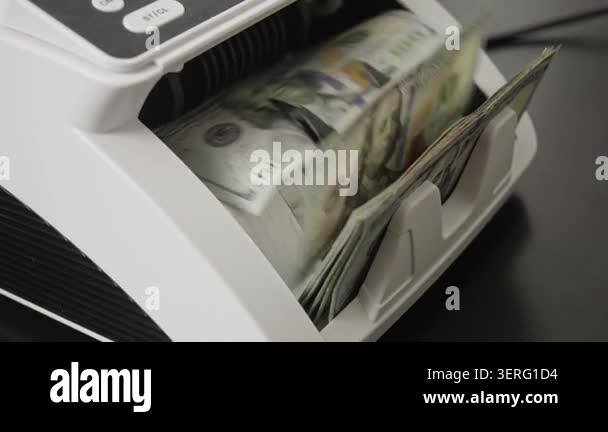 Counting hundred dollar bills. Cash counting machine working with US ...