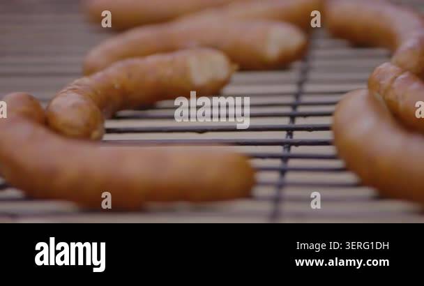 Close up view of browned sausages cooking on a grill rack with warm ...