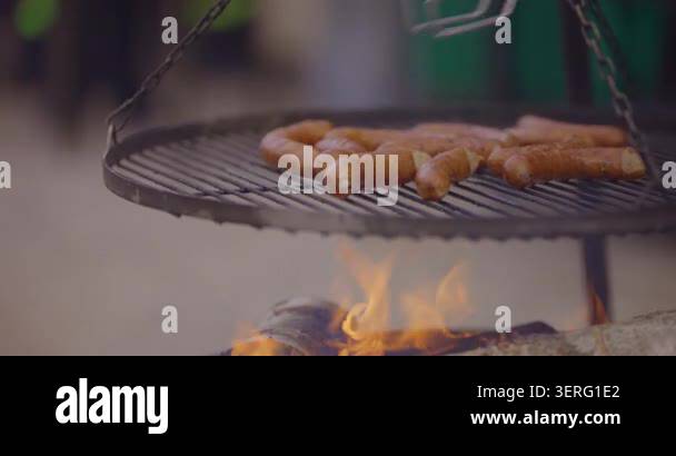 Close up view of browned sausages cooking on a grill rack with warm ...