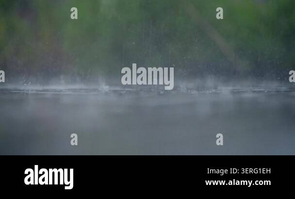 Moody abstract scene of raindrops sliding down wet glass with a soft ...