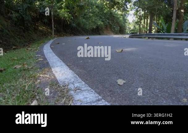 slow horizontal panning shot taken from a low angle on an asphalt ...