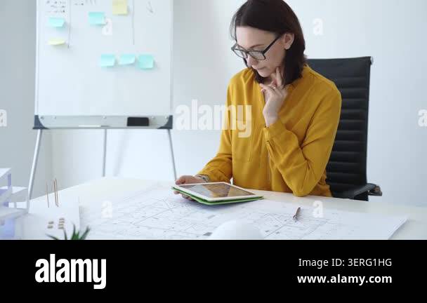 Woman architect or engineer sitting at her office desk, navigating a ...