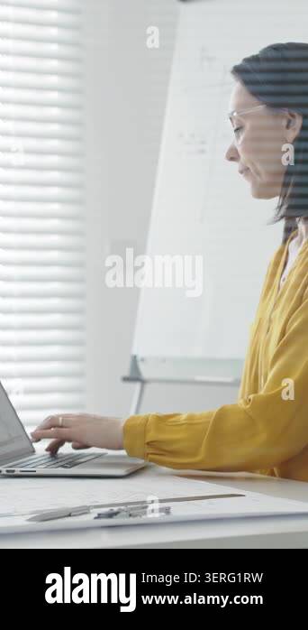 Woman architect working on a laptop, designing and planning ...
