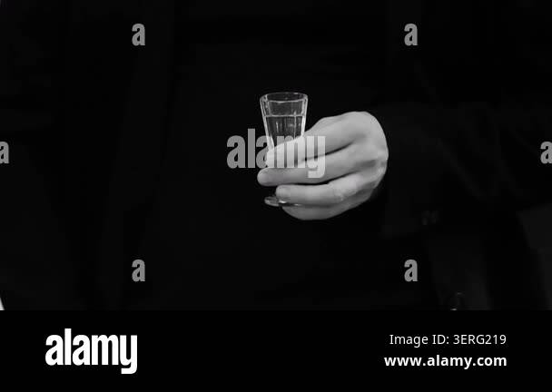 hand holding vodka shot glass dark symbolic mood bw. High quality 4k ...