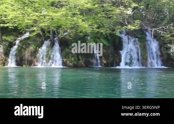 Scenic view of cascading waterfalls flowing into a clear turquoise lake ...