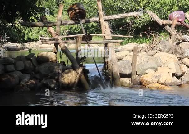Traditional water wheel mechanism made of wood and bamboo operating in ...