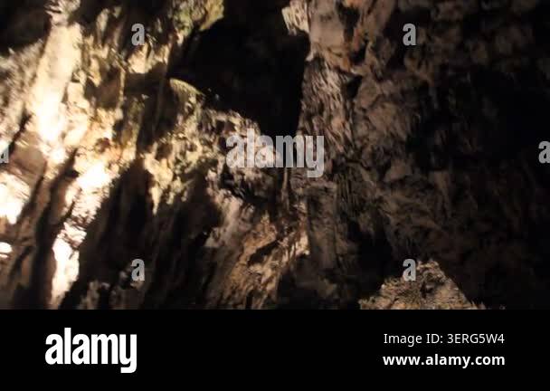Moving through a dark cave with illuminated rock formations and ...
