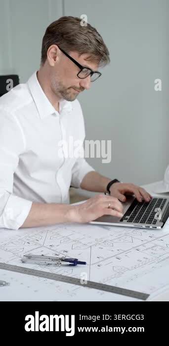 Dedicated architect or engineer working with focus on his computer ...