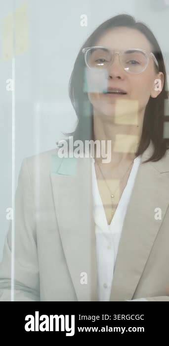 Young businesswoman with clear glasses actively discussing and ...