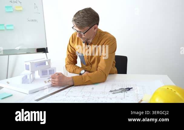 Architect or engineer meticulously drawing and analyzing detailed ...