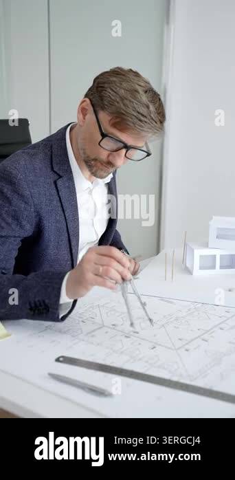 Architect carefully planning new real estate structure, using drafting ...