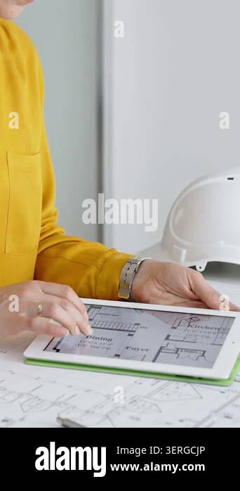 Professional woman architect reviewing and drawing blueprints while ...