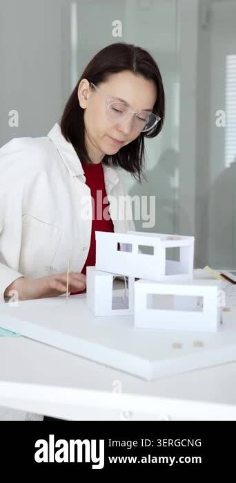 Woman architect focusing on architectural drawings and blueprints ...