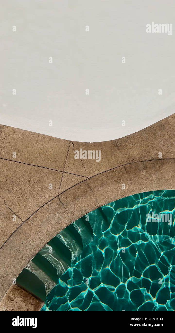 from above: pool and white negative space and woman gets out of pool ...
