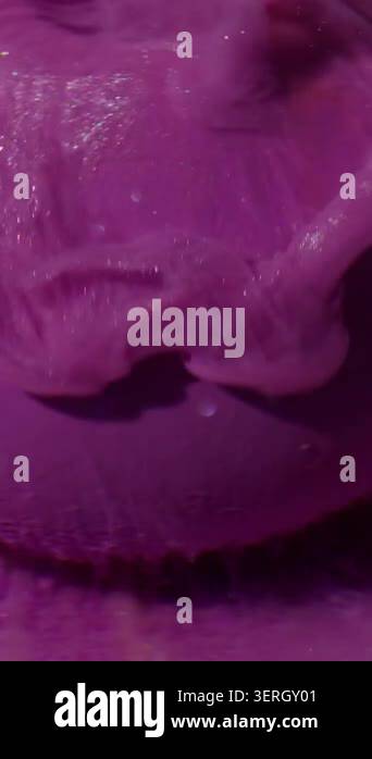 Vertical video. Dye spill. Blur paint wave. Sparkling pink purple ...