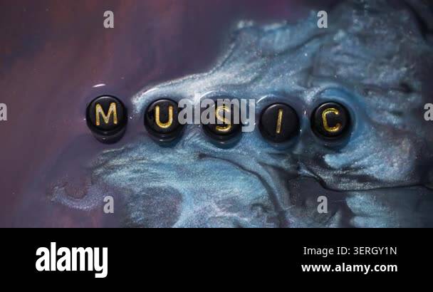 Music letter. Blue ink splatter. Defocused yellow purple black color ...