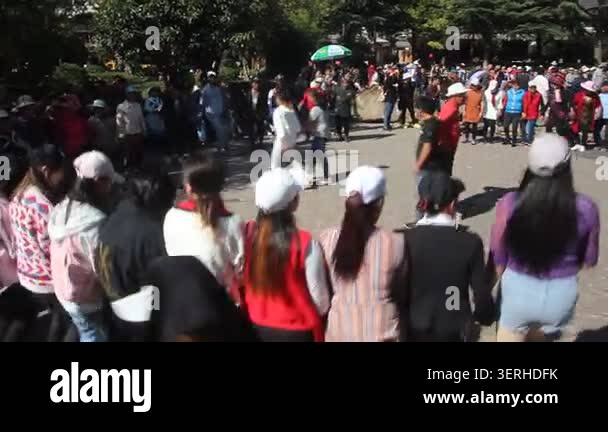 Group of people gathered in a circle outdoors, watching a performance ...