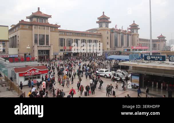 Busy train station exterior with many people walking and pulling ...