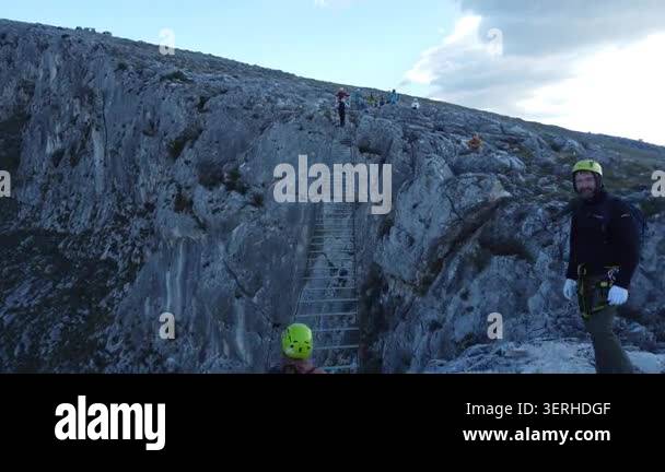 group of people climbing on top of rock in the mountain Stock Video ...