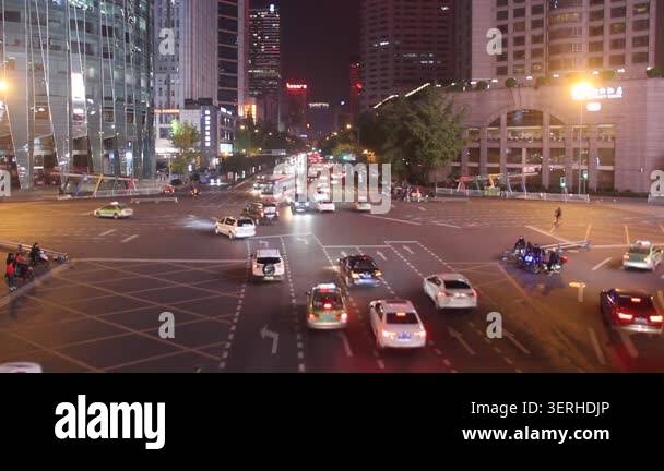 Busy city intersection at night with traffic flowing through ...