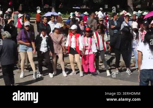 Group of people dancing in traditional clothing outdoors during a sunny ...