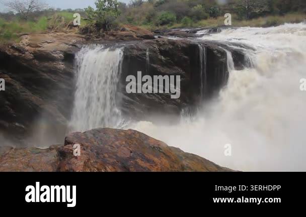 Powerful waterfall cascading over rocks with white water spray creating ...