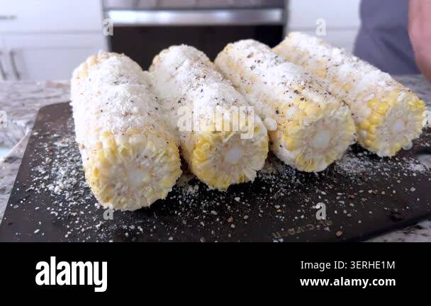 Interior kitchen shot of a tray with multiple corn cobs arranged side ...