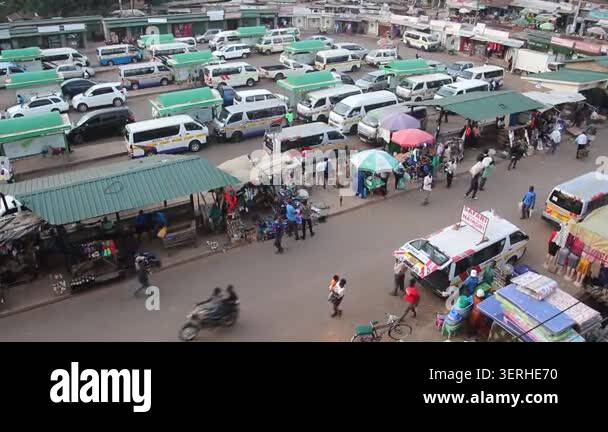 Busy marketplace with many vans parked and people walking around stalls ...