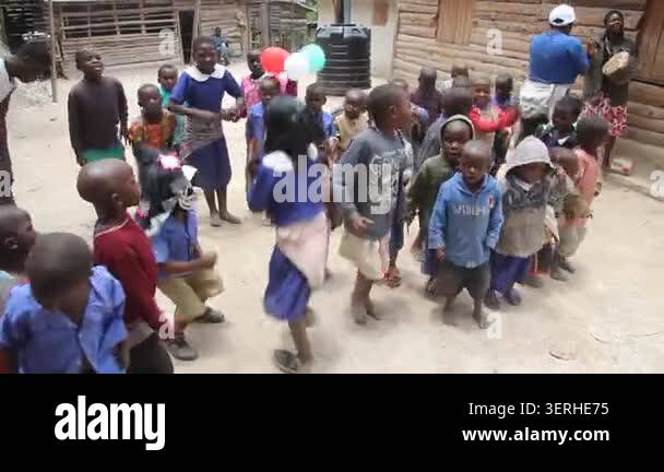 Group of children dancing and playing outdoors in a village setting ...