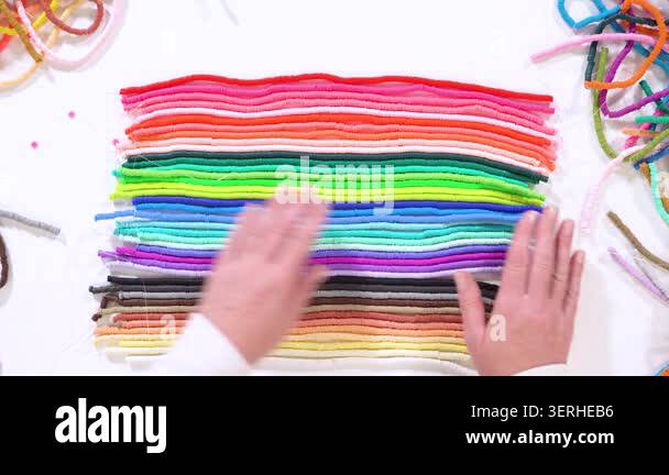Flat lay. Artistic hands lift a selection of brightly colored clay bead ...