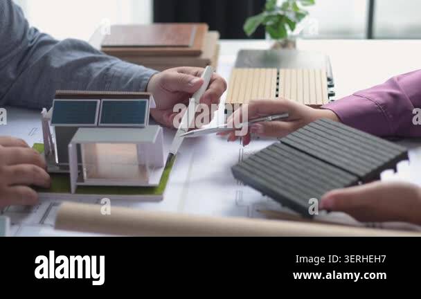 Architect and interior designer collaborating on floor plans and ...