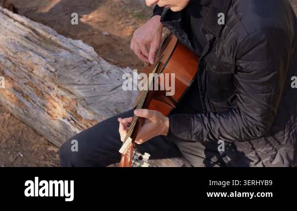 Close up hands of man playing acoustic guitar and singing relaxing ...