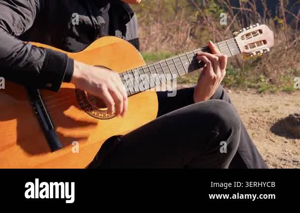 Close up hands of man playing acoustic guitar and singing relaxing ...