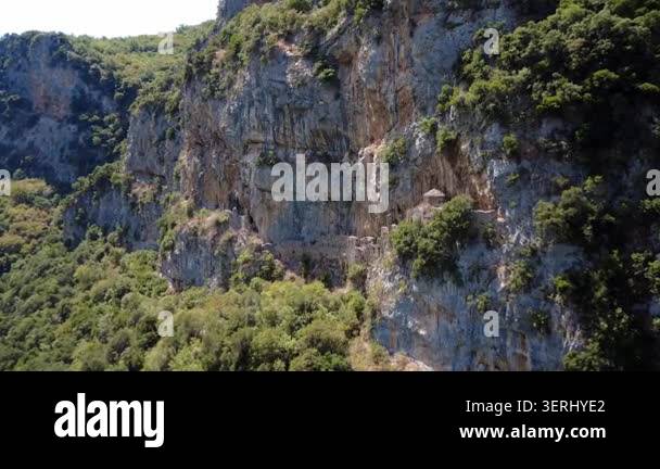 Ancient stone walls and a church inside a cave carved into the mountain ...