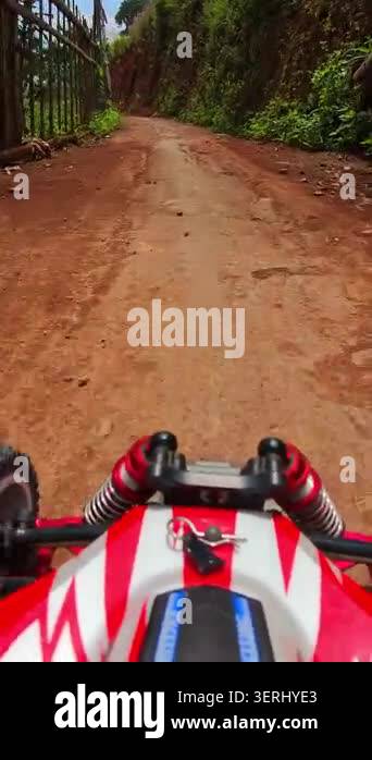 Vertical Footage of Red and white Buggy Toy car moving along a muddy ...