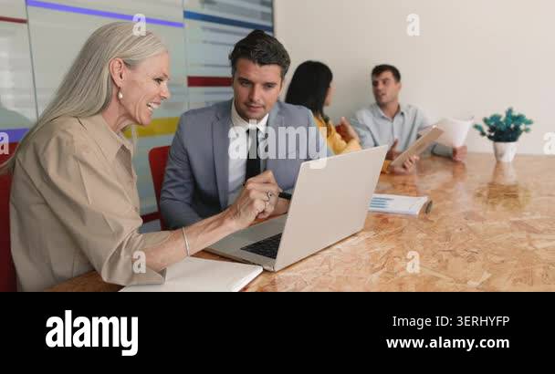 Two positive diverse different aged business colleagues discussing ...