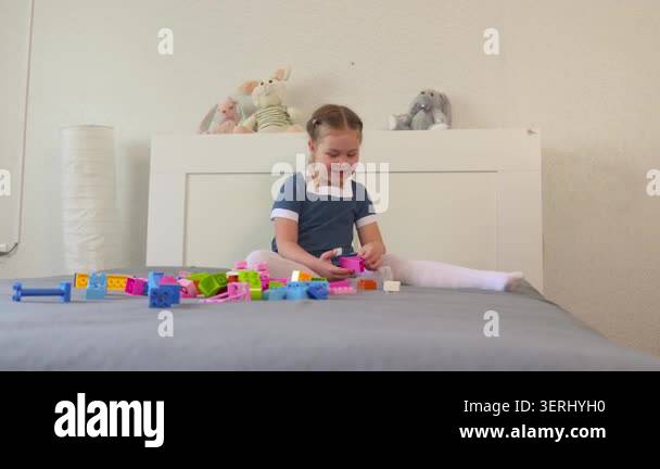 Young girl uses colorful building blocks during a learning activity ...